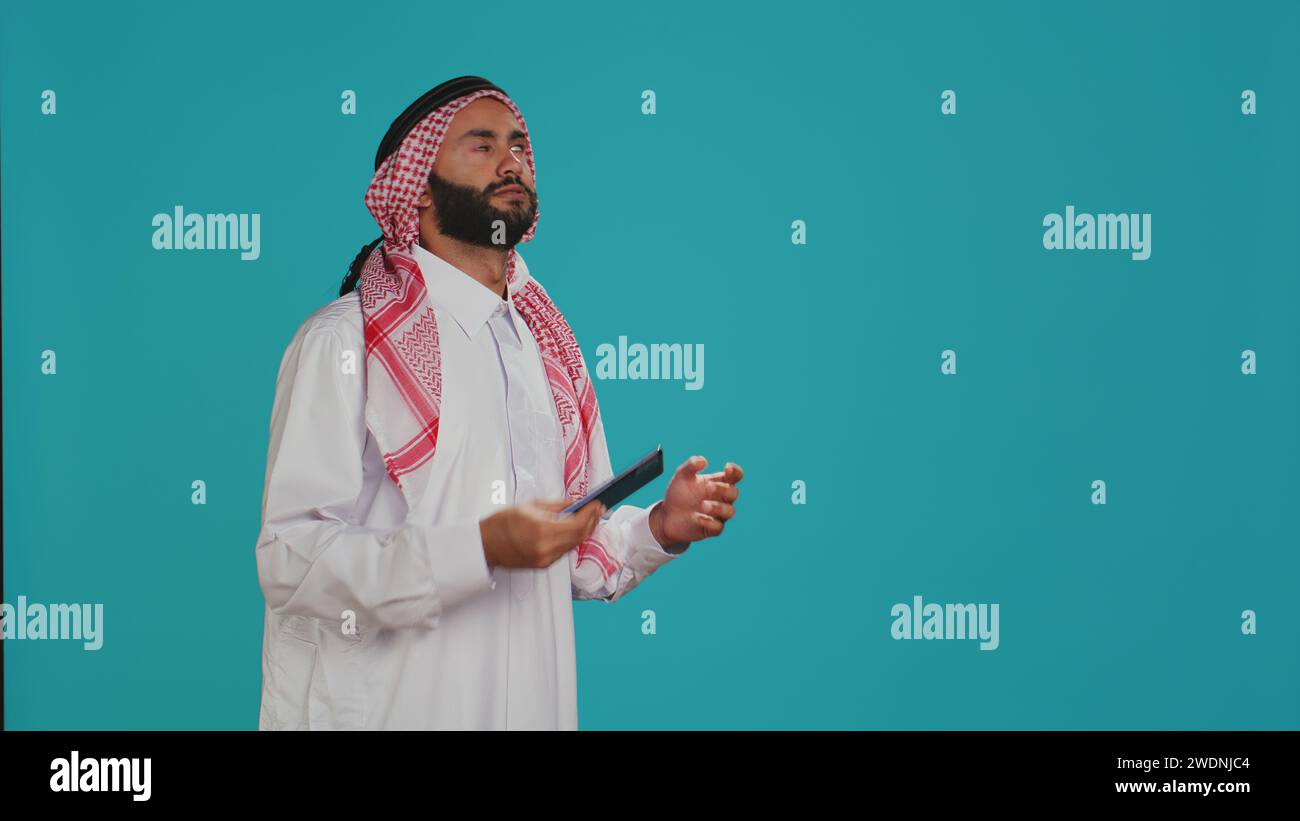 Middle eastern man plays videogames on phone with tensed focused ...