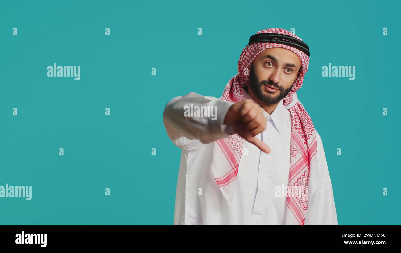 Muslim guy with ancient gown and kufiyah gives thumbs down and feels ...