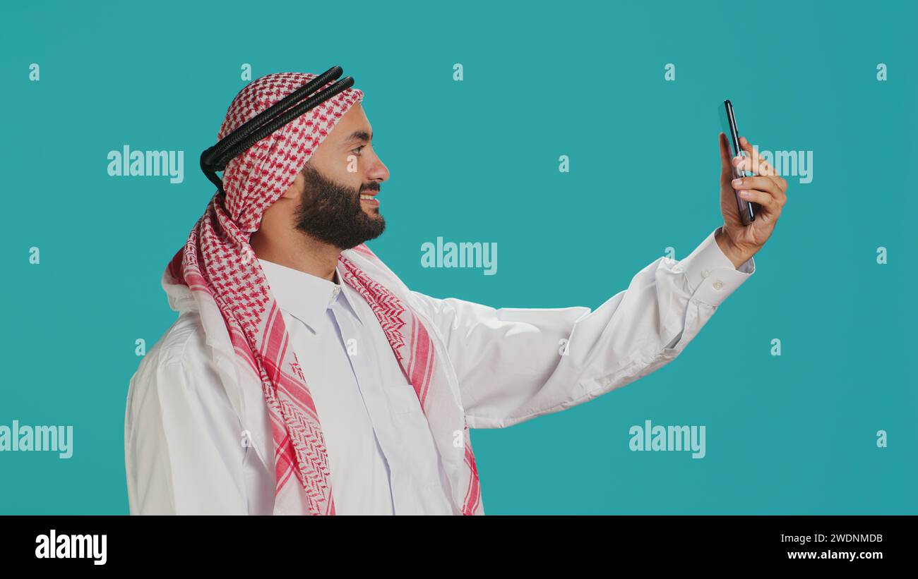 Young muslim guy takes pictures with phone, capturing important things ...