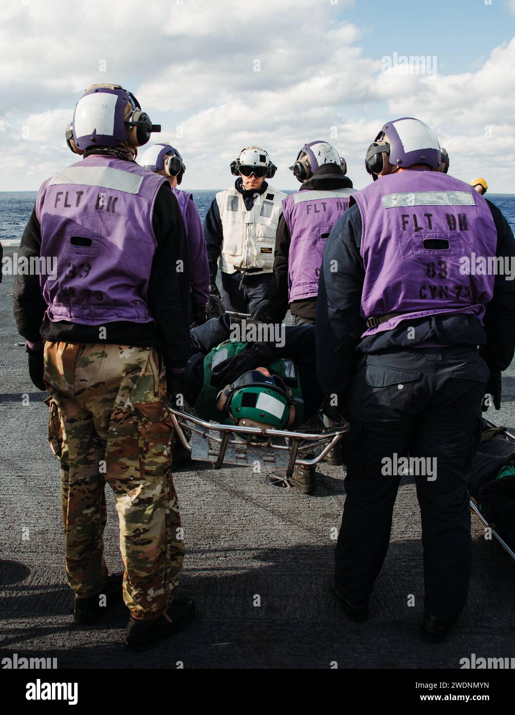Sailors carry a simulated injured Sailor during a mass casualty drill ...
