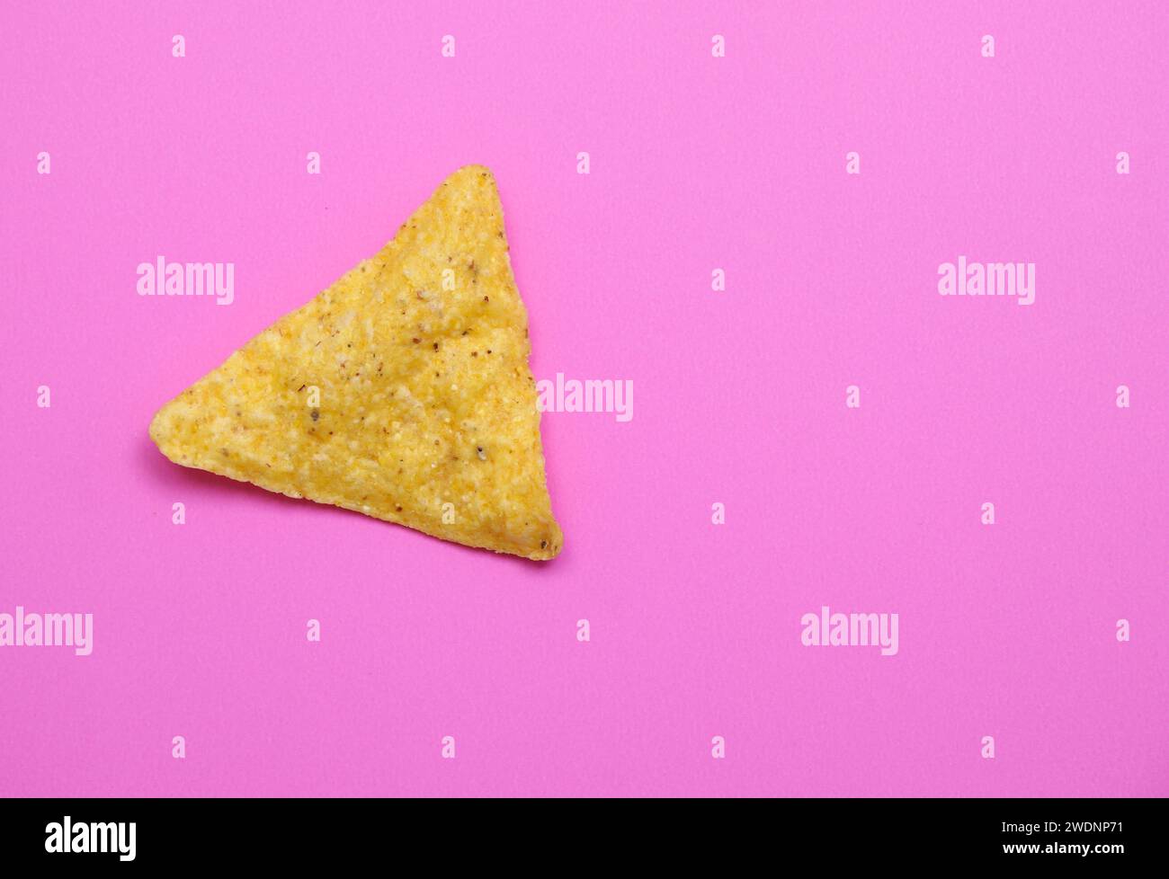 One tortilla chip isolated on bright pink background Stock Photo - Alamy
