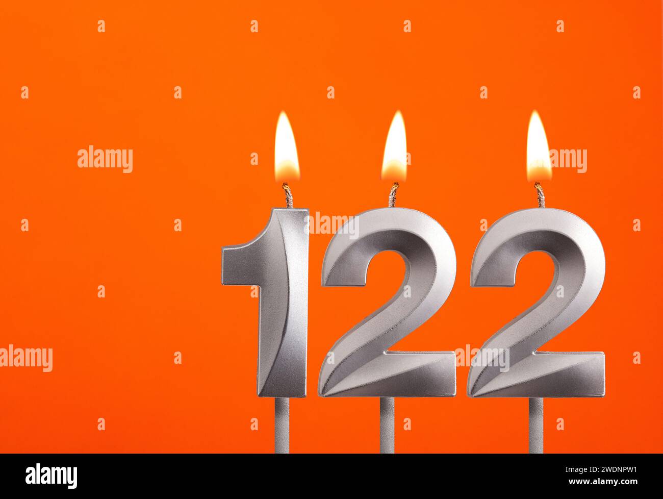 Candle number 122 - Birthday in orange background Stock Photo - Alamy