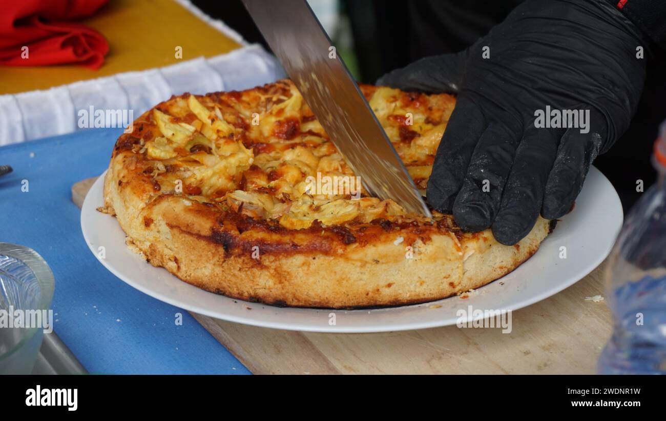 The chefs serving golden brown pizza for the customer, looks so ...