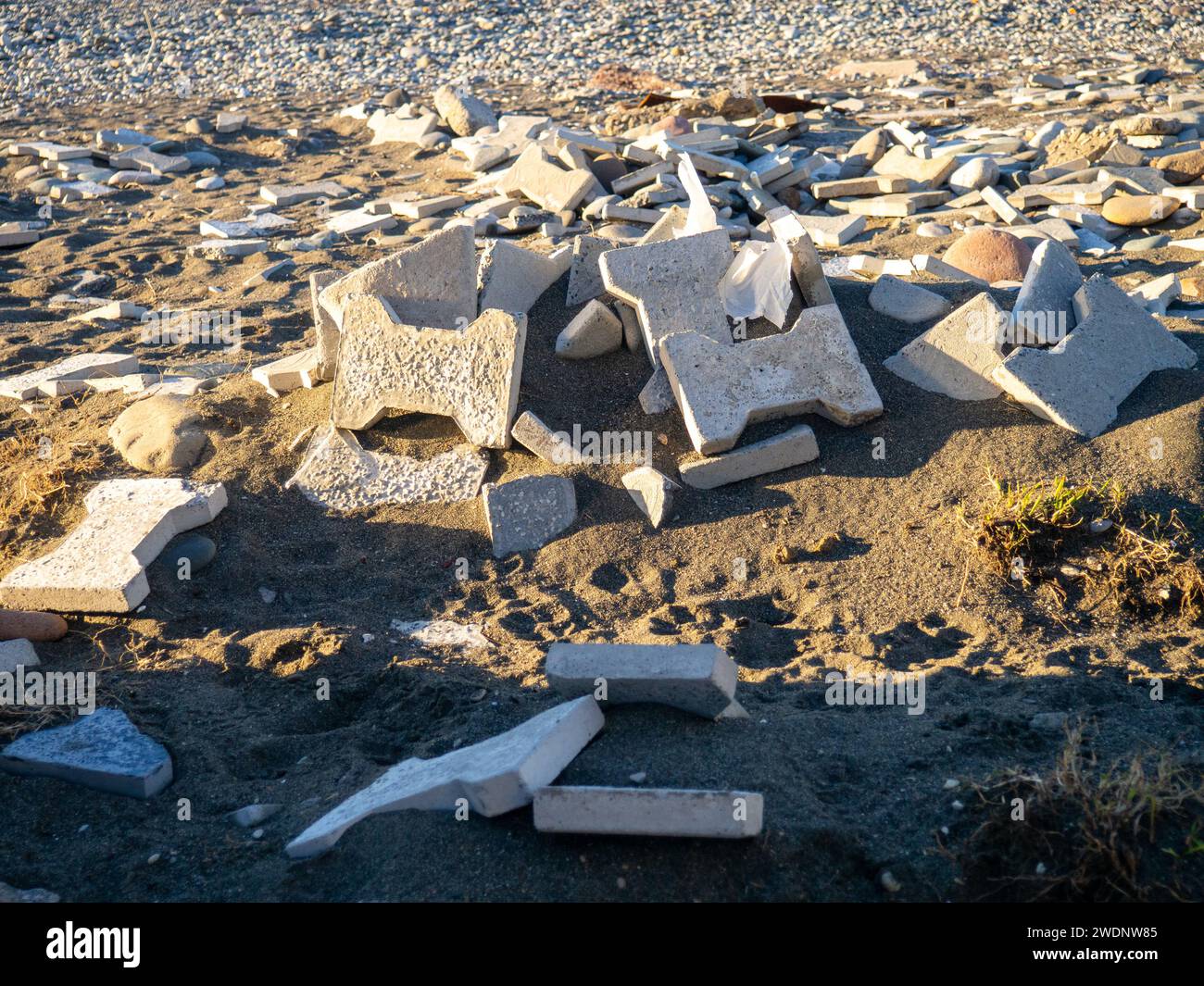 Paving slabs are scattered on the sand. Embankment after the storm ...