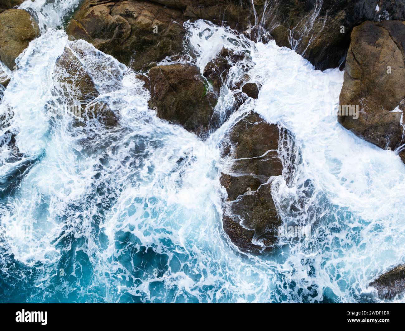 Waves crashing on seashore rocks,Top view sea surface waves background ...