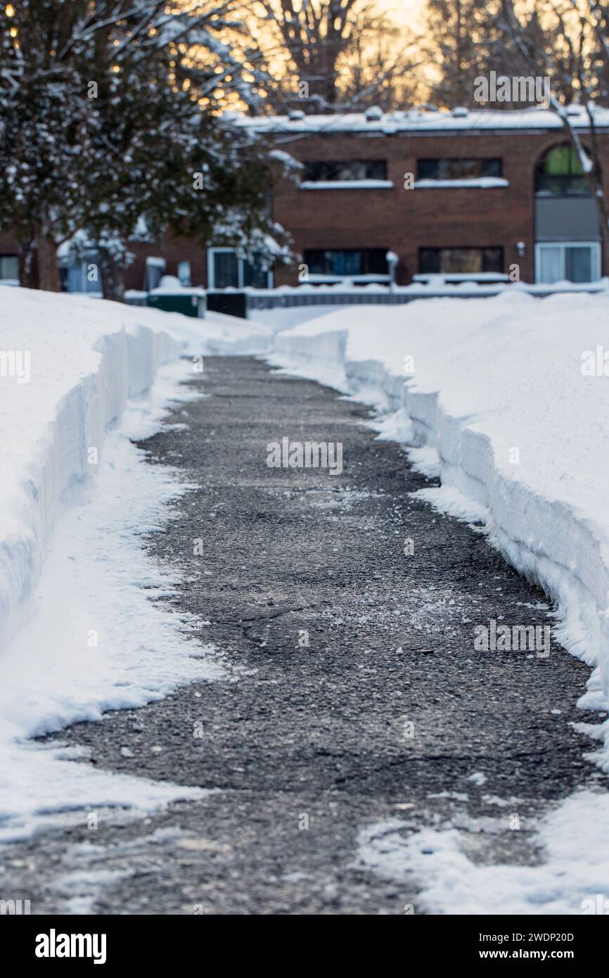 Winter road cleared of snow. Salt used to melt snow near houses Stock ...