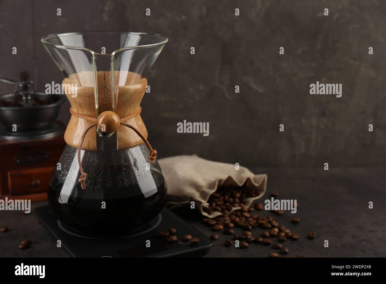 Making drip coffee. Glass chemex coffeemaker, beans and scales on gray ...