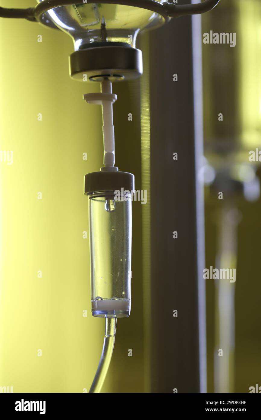 IV drip chamber against blurred yellow background Stock Photo - Alamy