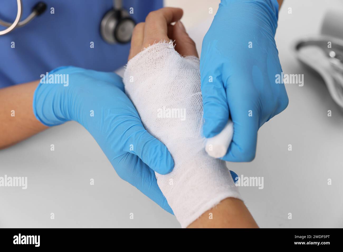 Doctor bandaging patient's burned hand at table, closeup Stock Photo ...
