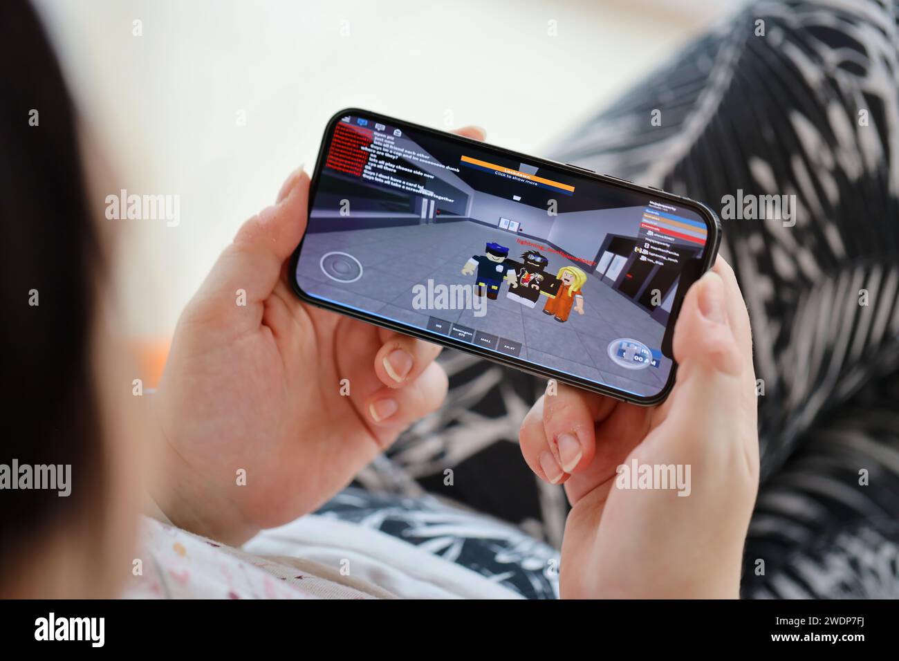 Roblox mobile iOS game on iPhone 15 smartphone screen in female hands ...