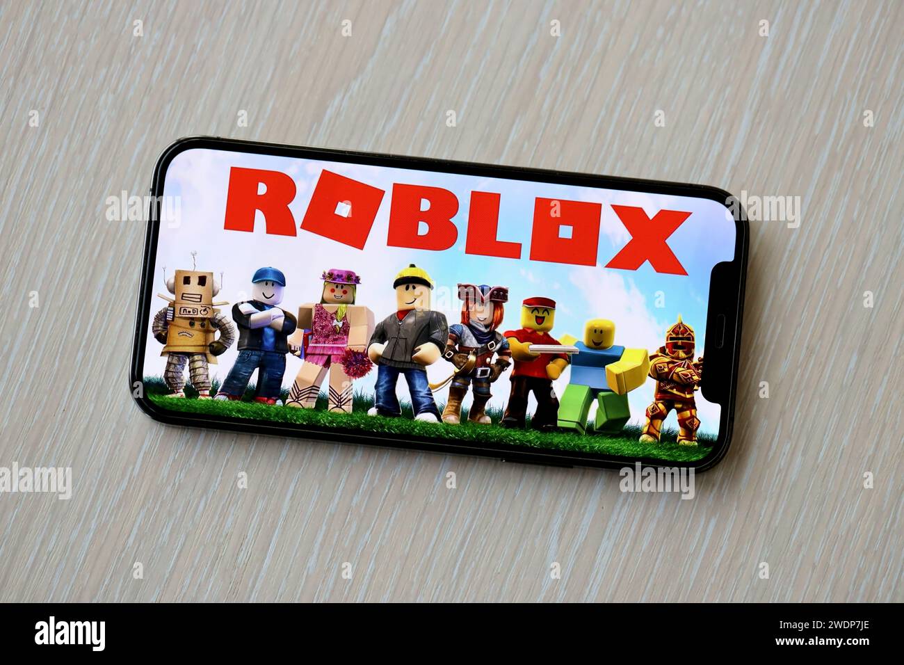 Roblox mobile iOS game on iPhone 15 smartphone screen on wooden table ...