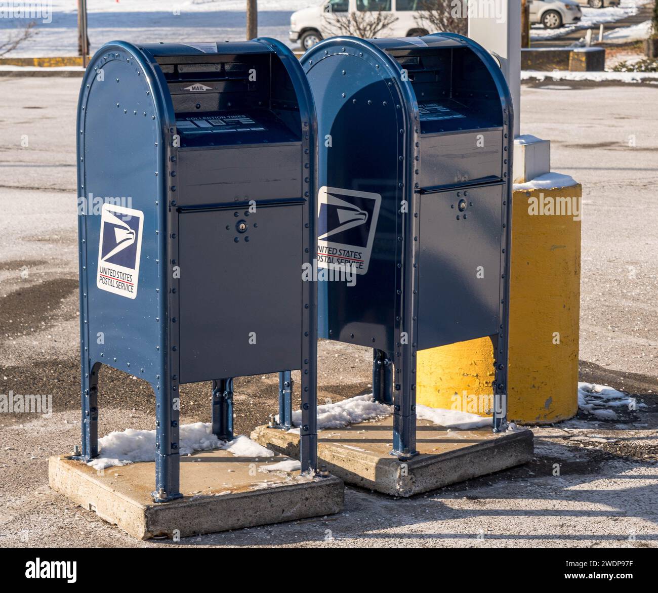 Two United States Postal Service mailboxes in a parking lot outside of ...