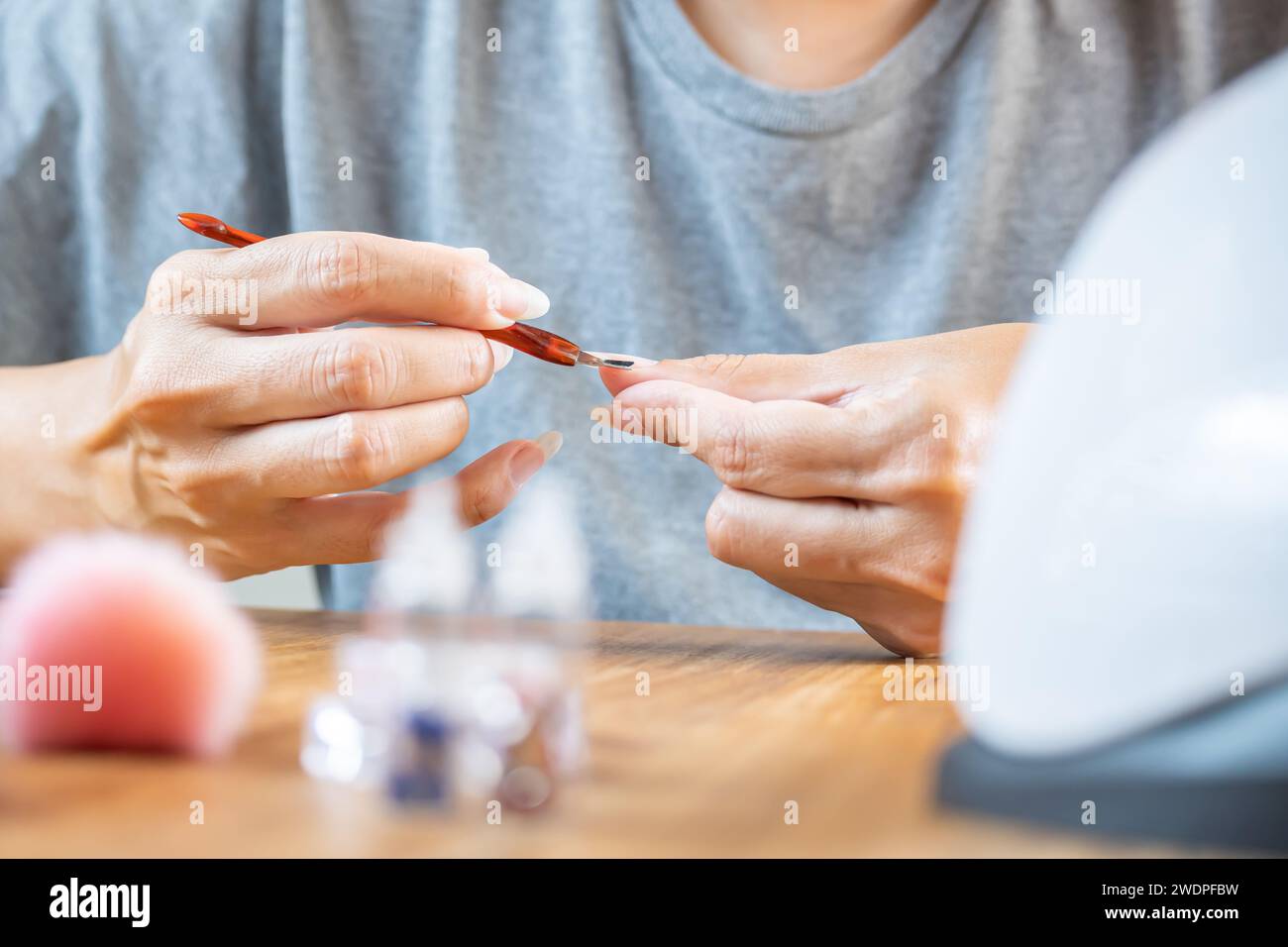 Woman using a cuticle remover, preparation before applying paint on ...