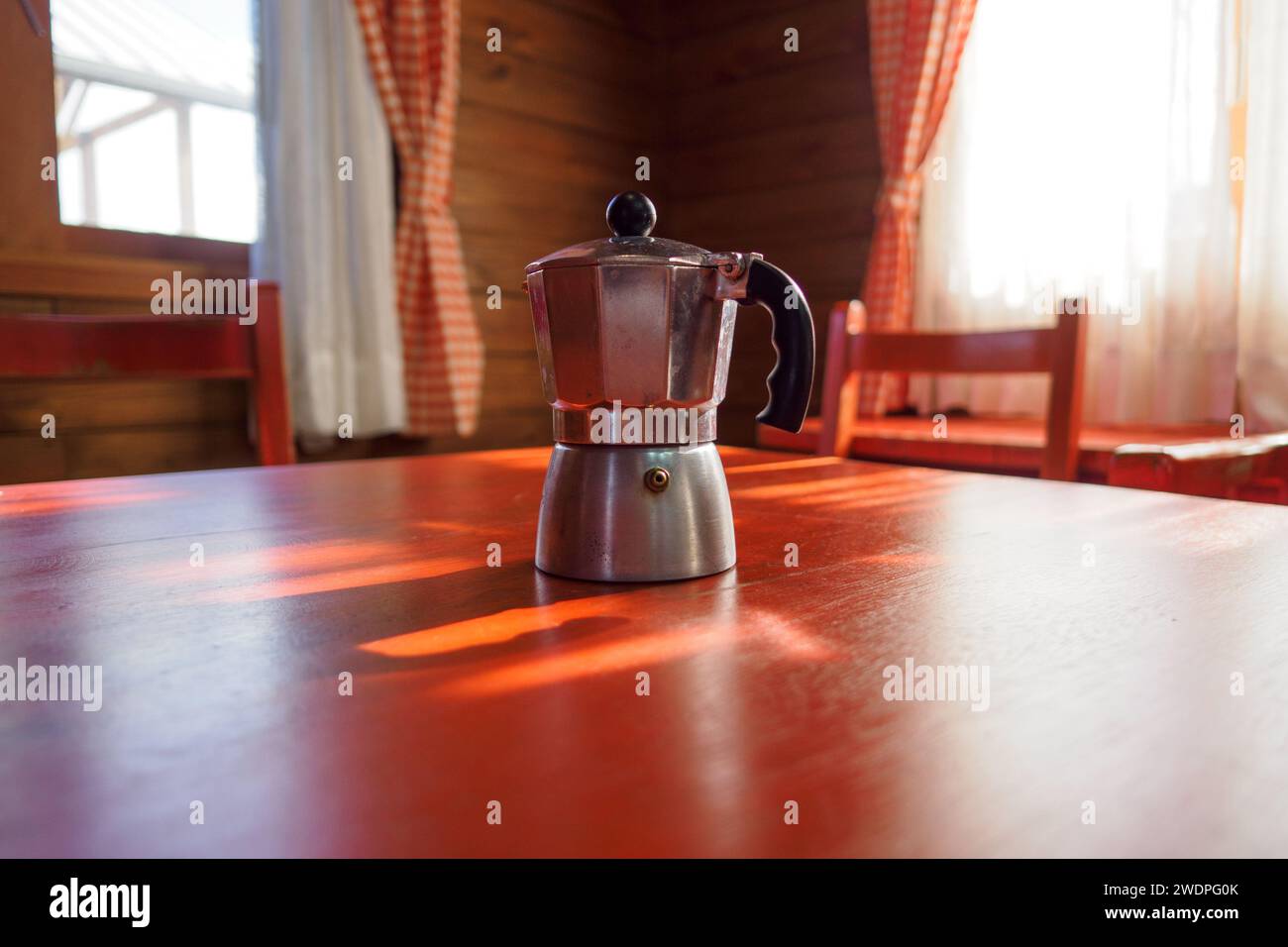 Coffee maker on red table at sunny morning Stock Photo - Alamy