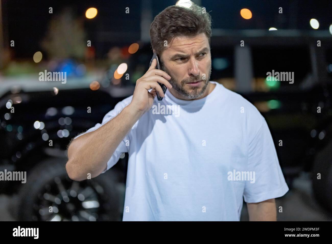 Angry man talking on phone on night urban street. Dangerous aggressive ...