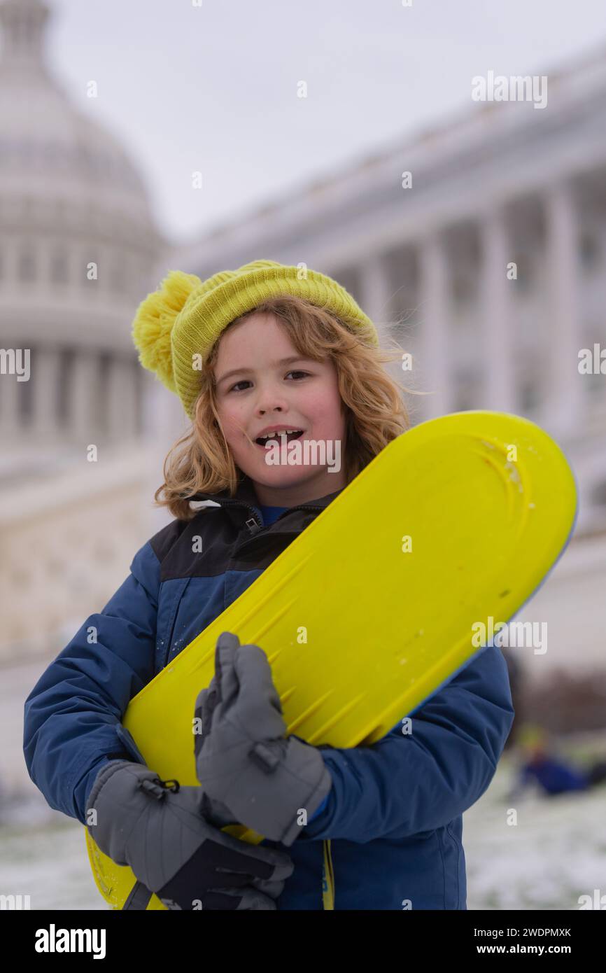 Kids play with snowboard in winter park. First Winter snow. Kids ...