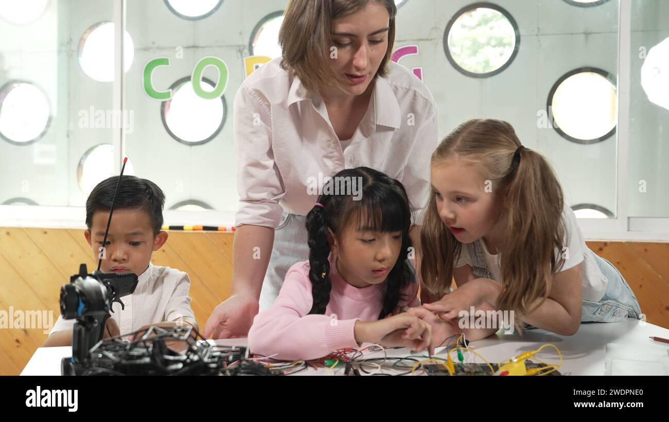 Teacher looking at children while diverse student looking at screen ...