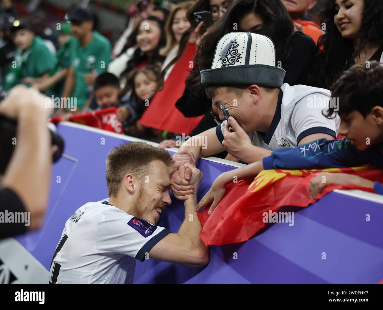 Doha, Qatar. 21st Jan, 2024. Aleksandr Mishchenko (L) of Kyrgyzstan shakes hands with fans after ...