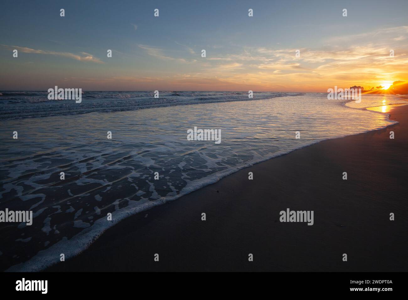A scenic view of a sunset over a beach on the Gulf of Mexico in ...