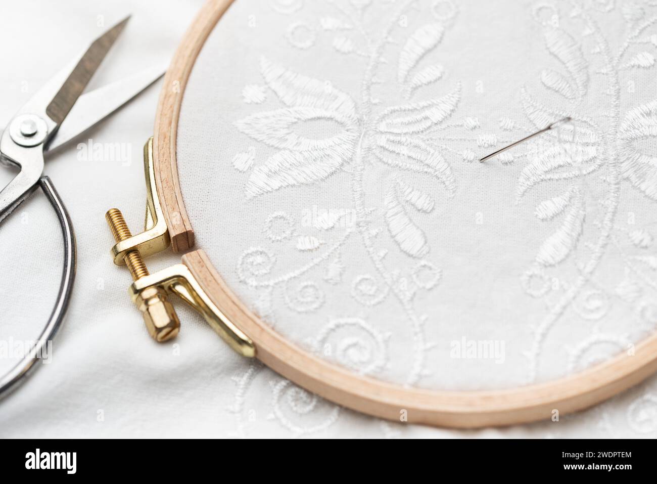 The process of hand embroidering a shirt with white threads on white ...