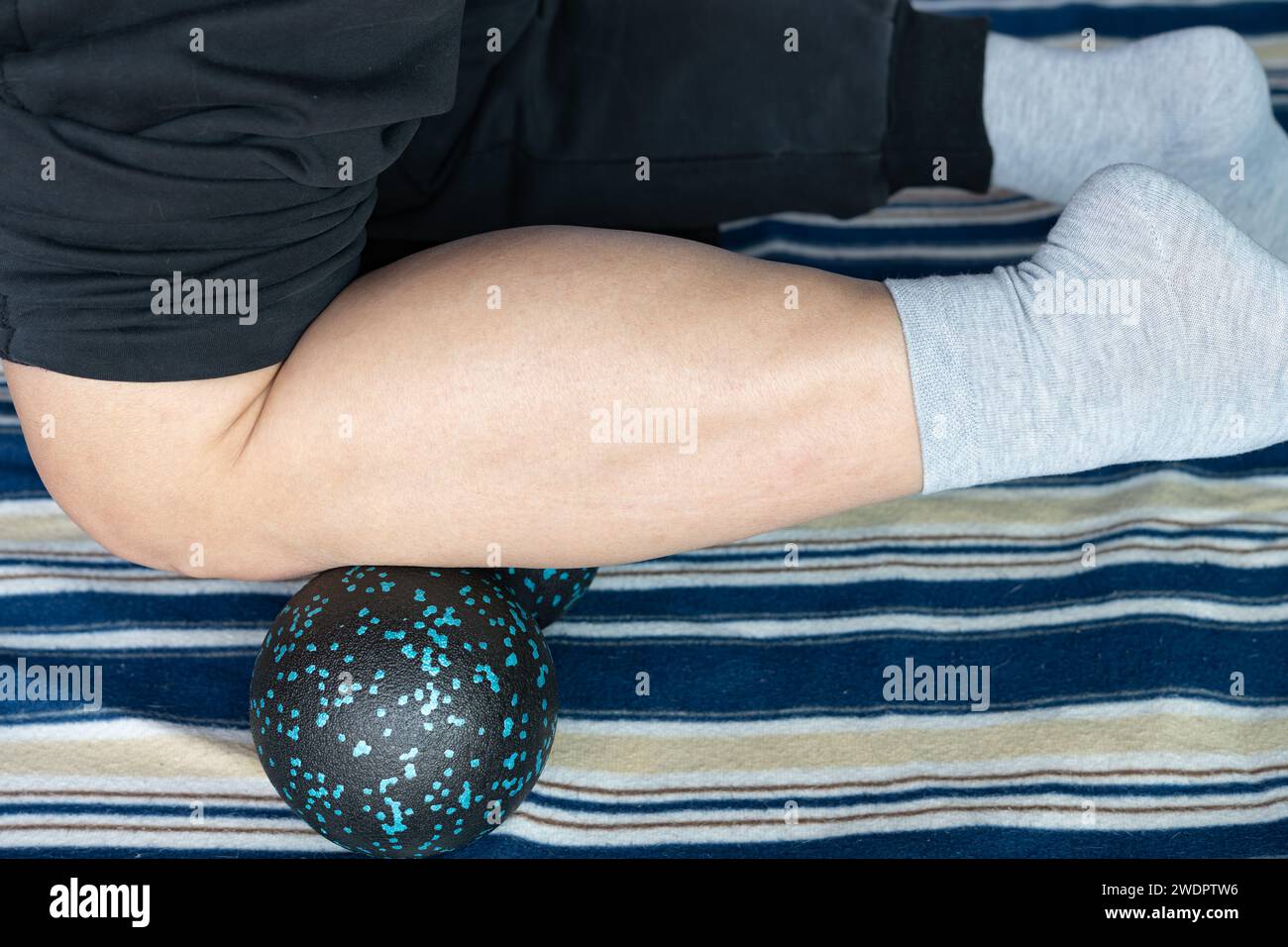 man using peanut-shaped massage balls to relax his anterior tibialis at ...