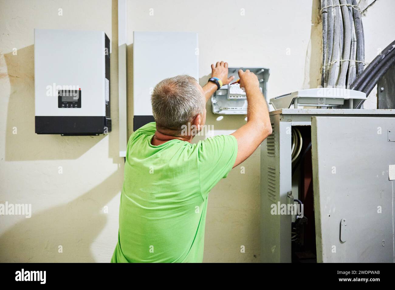 Man electrician installing solar panel system. Inspector making ...