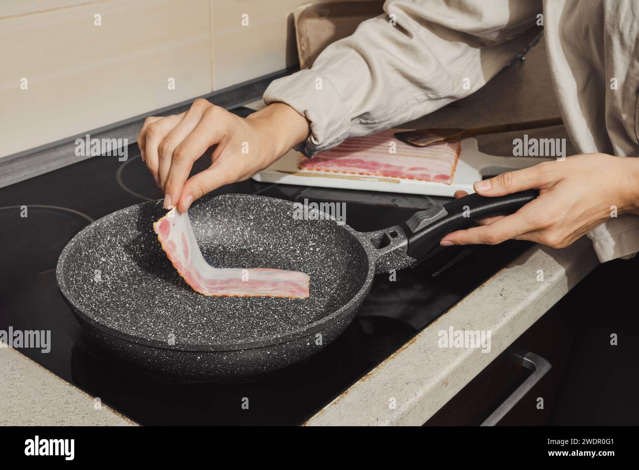 Woman frying bacon hi-res stock photography and images - Alamy