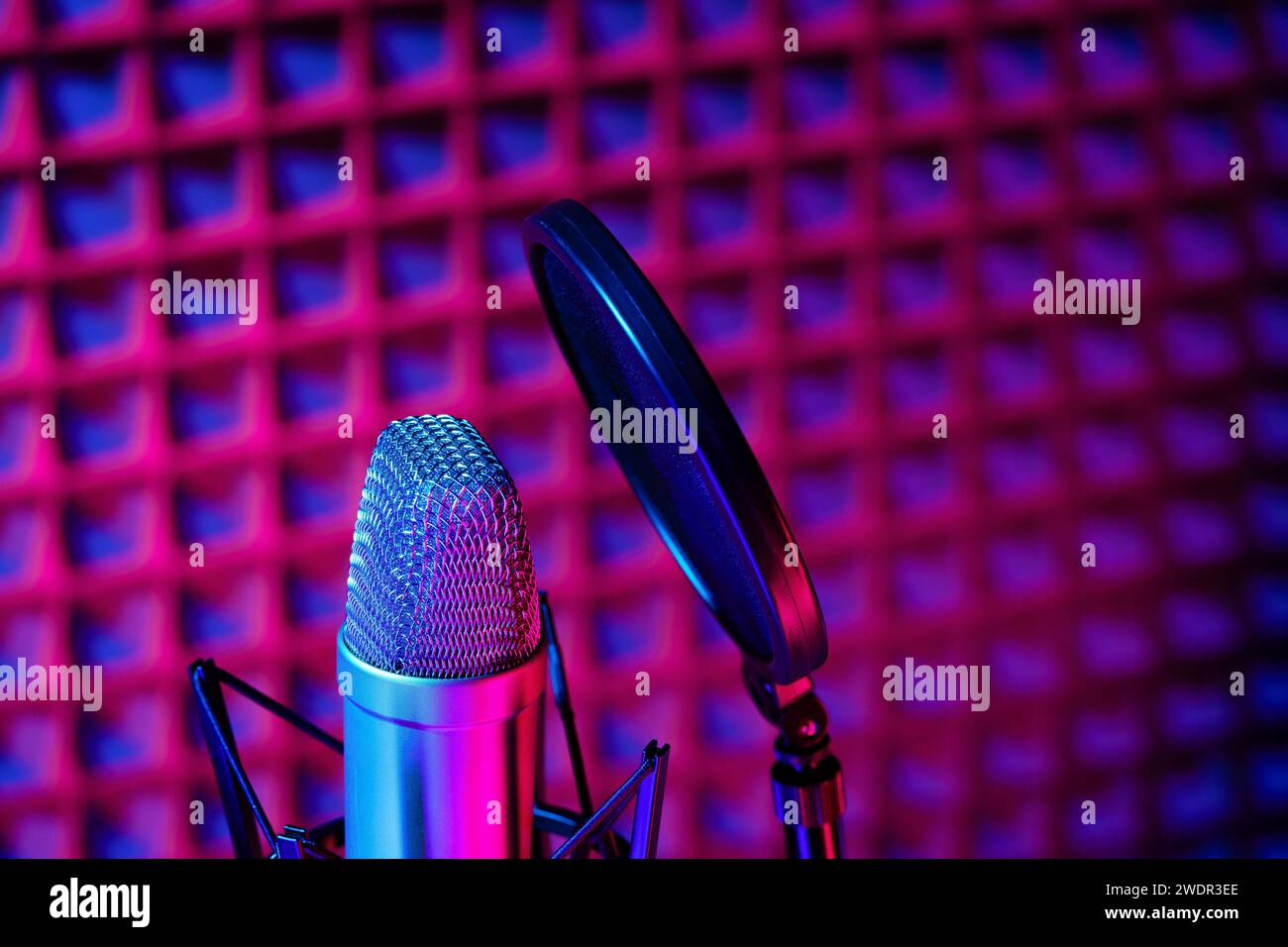 Professional studio microphone against acoustic foam panel background ...