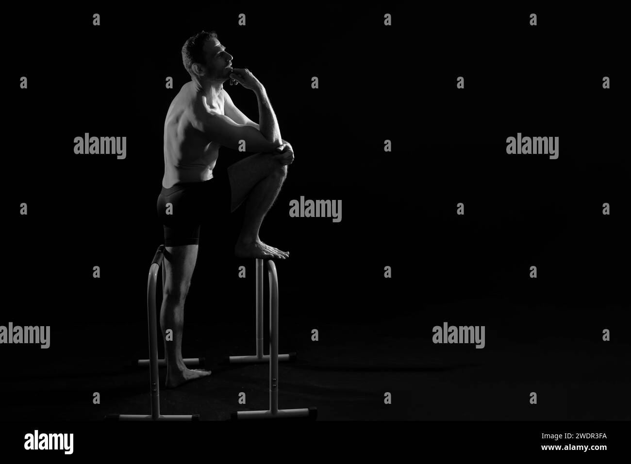 Male gymnast performing handstand on a parallel bars, studio shot Stock ...