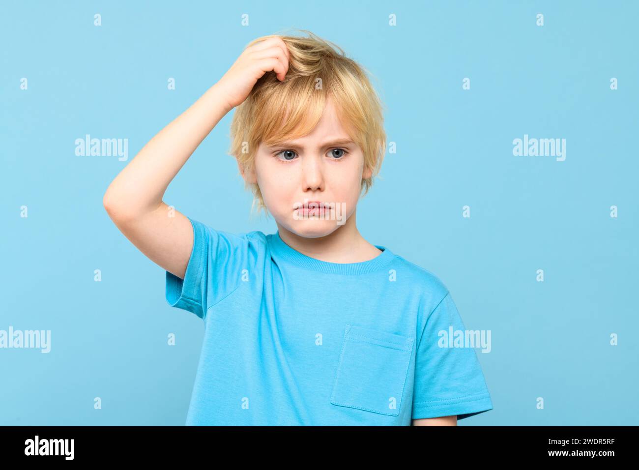 Young doubtful confused boy thinking, scratching head, trying to find ...