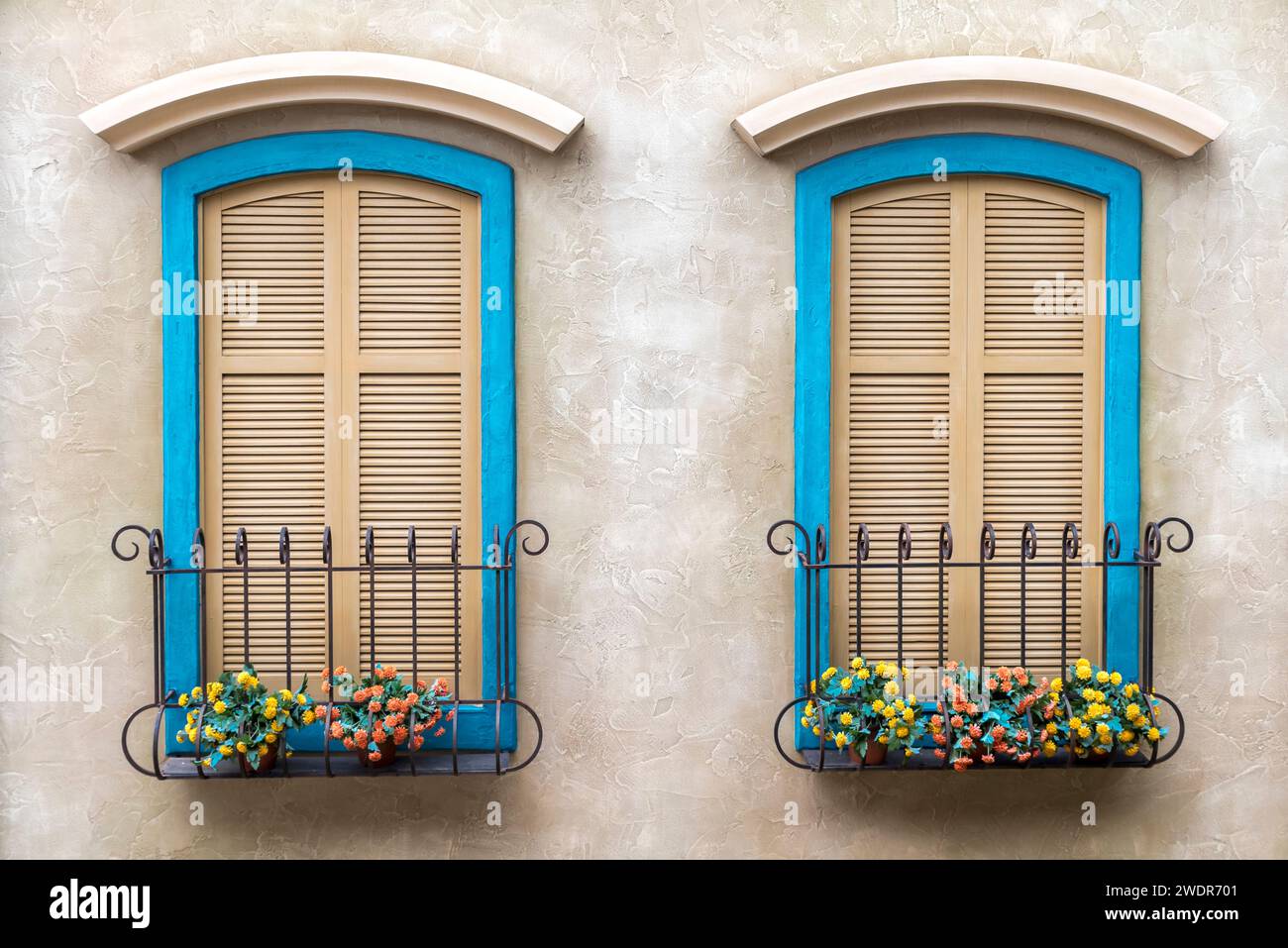 Two windows, with bright blue frames, and shutters on the glass. The ...