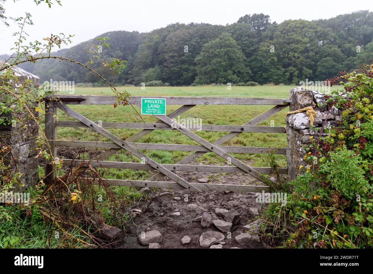 Wooden gate, leading to a rural field. The gate has a sign stating ...