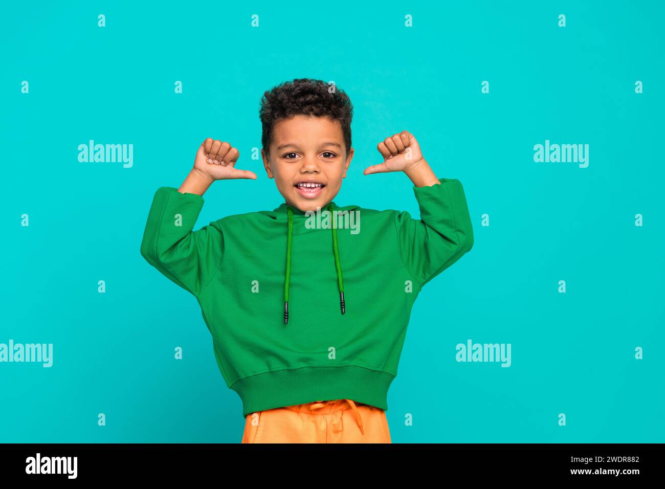 Photo of cheerful charming boy dressed stylish green clothes thumbs ...