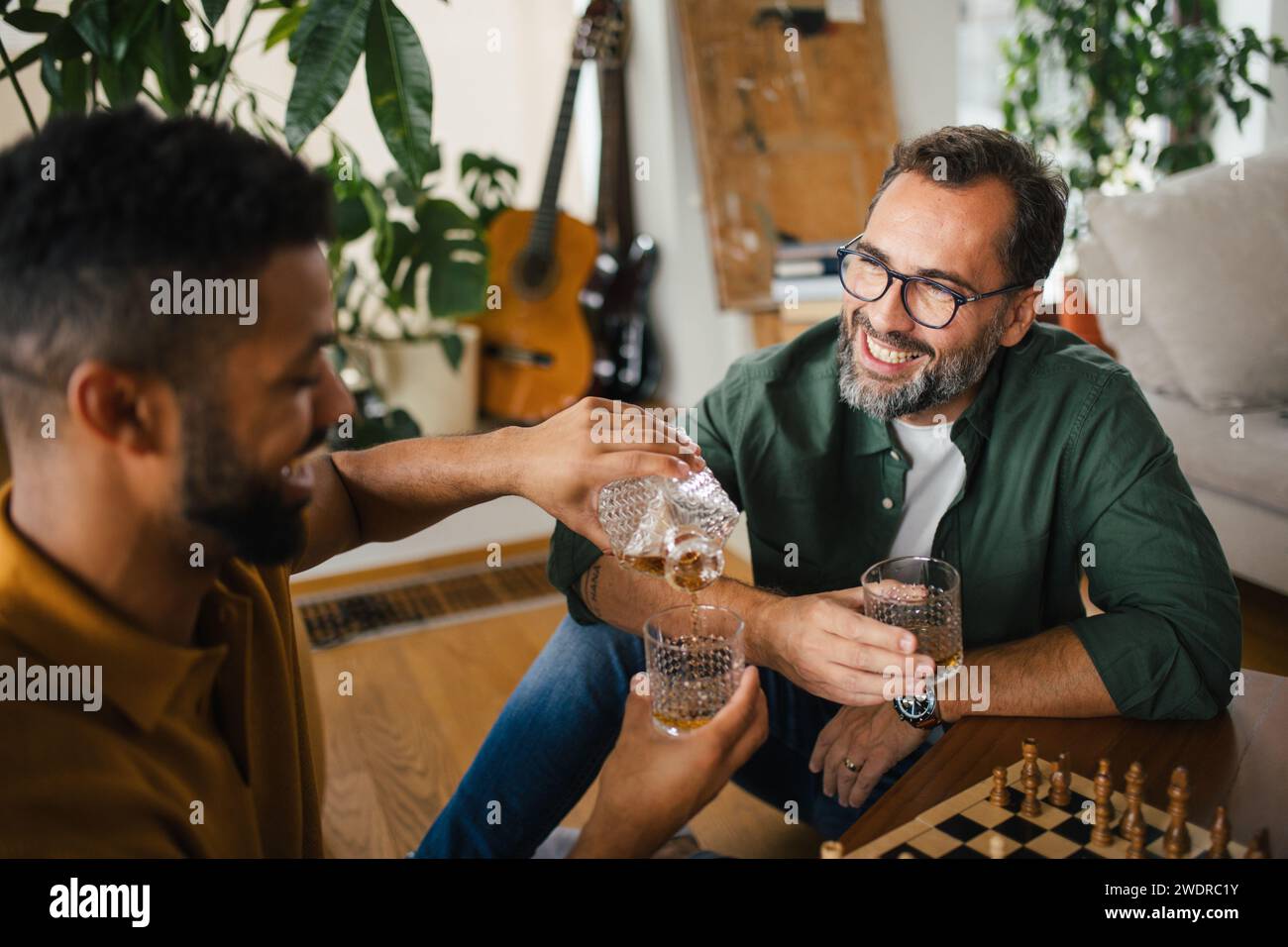 Best friends playing chess together, drinking whiskey and talking ...