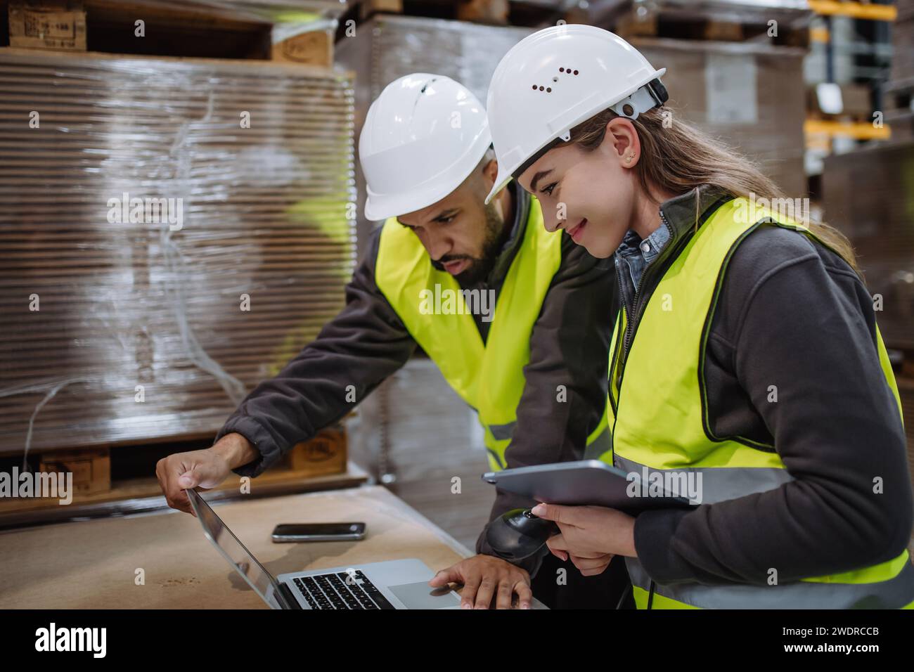 Warehouse manager talking with logistics employee in warehouse ...