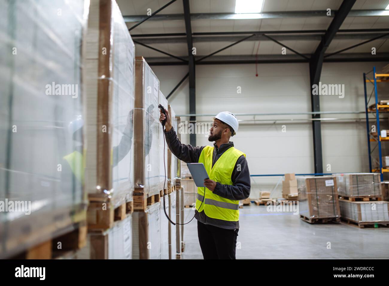 Warehouse worker holding scanner, scanning the barcodes on products in ...
