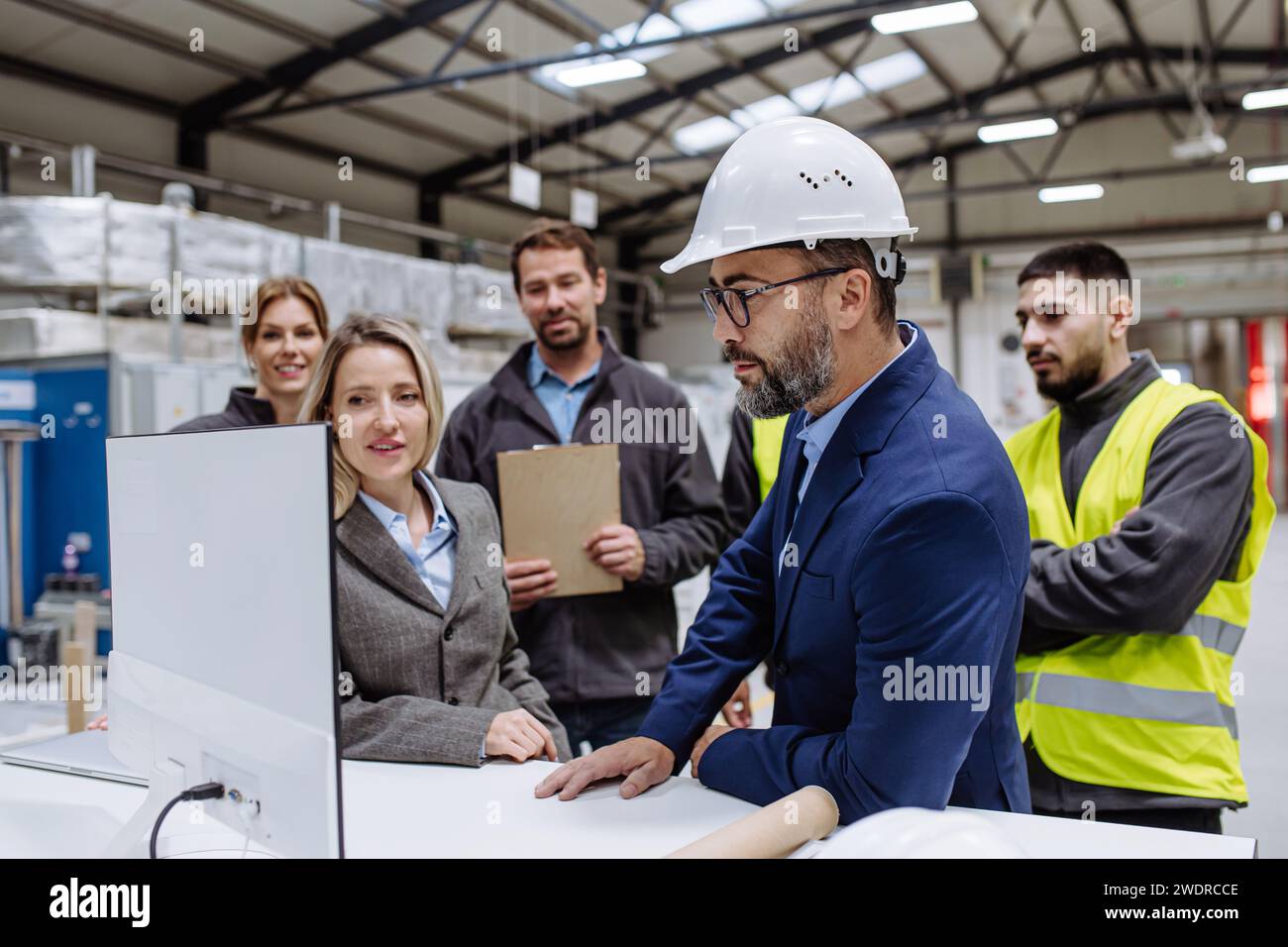 Manager presenting project to full team of warehouse employees on ...