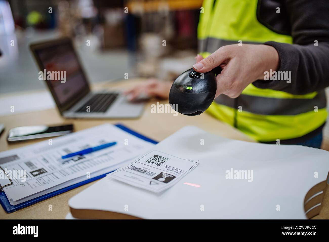 Female warehouse worker holding scanner, scanning the barcodes on ...
