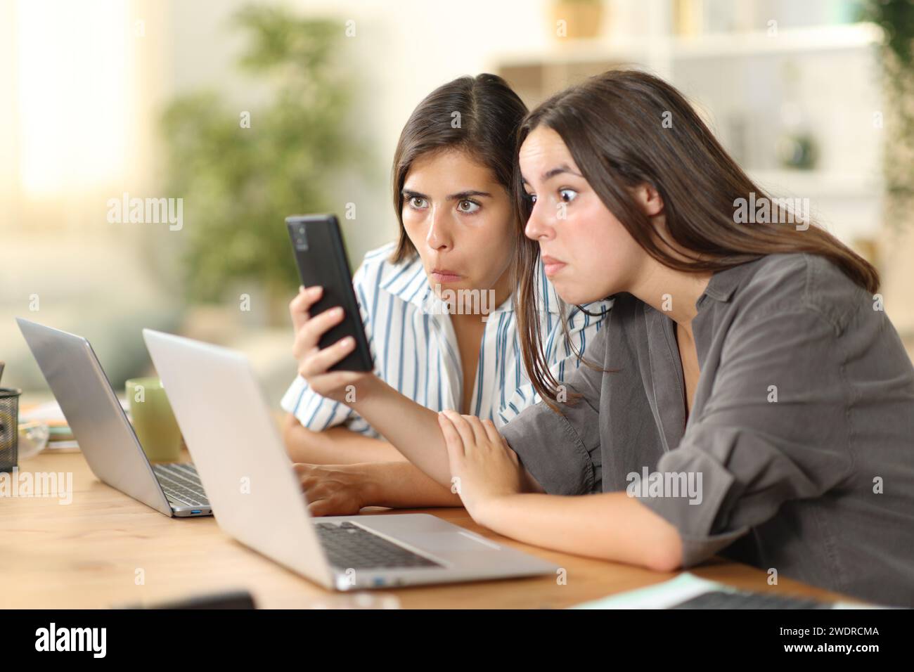 Perplexed tele workers checking amazing phone content at home Stock ...