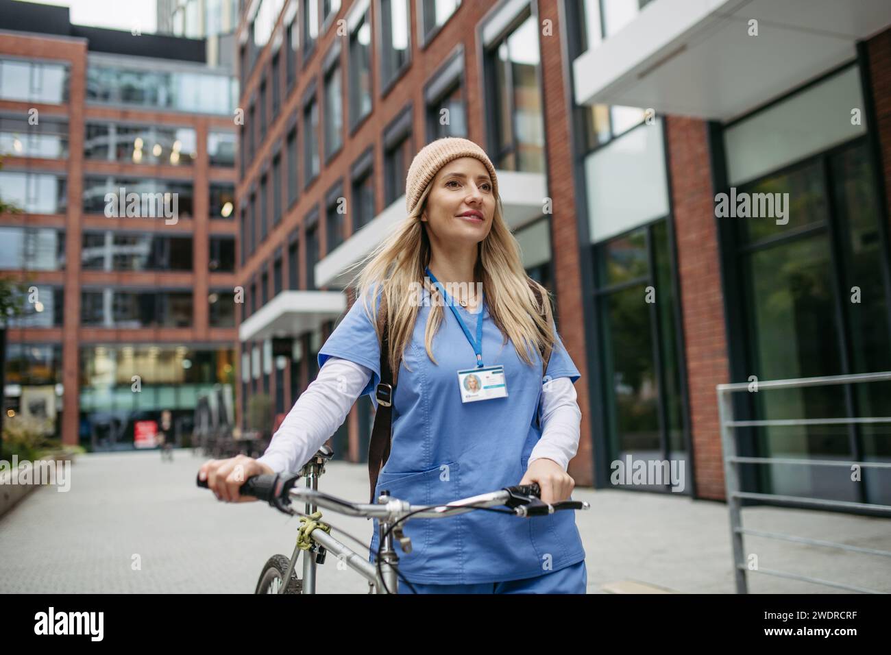 Beautiful nurse commuting through the city by bike. Doctor city ...