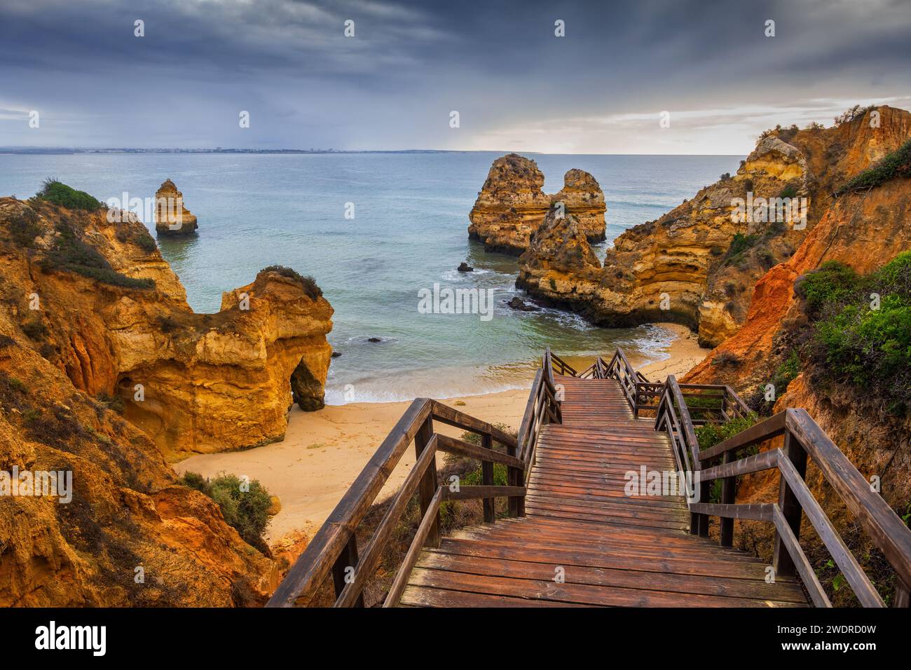 Algarve coast in Lagos, Portugal, Praia do Camilo with wooden stairs to ...