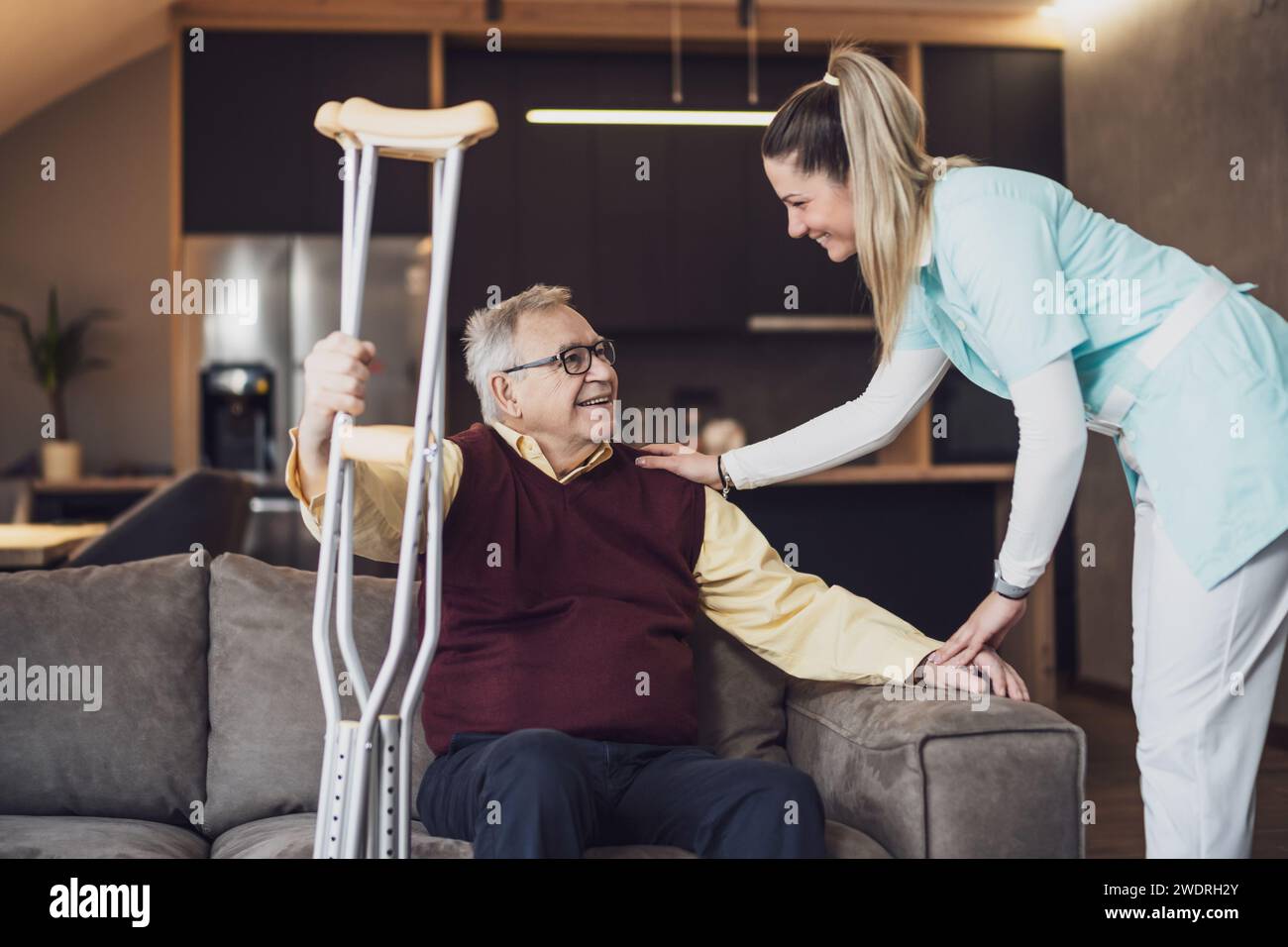 Nurse home caregiver is assisting old man at his home. Professional ...