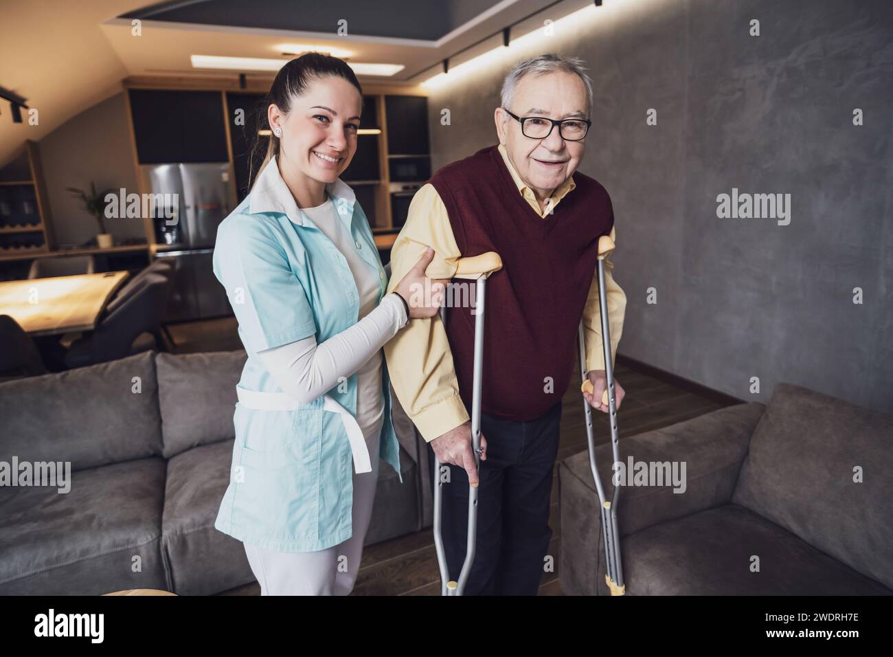 Nurse home caregiver is assisting old man at his home. Professional ...