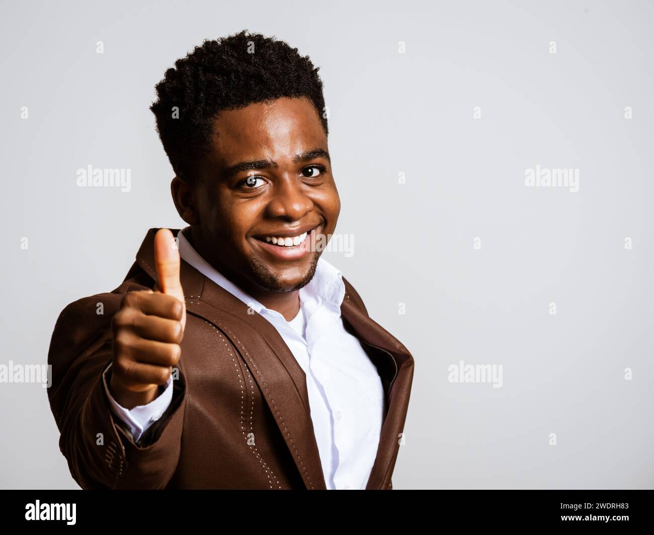 Portrait of happy businessman who is smiling and showing thumbs up ...