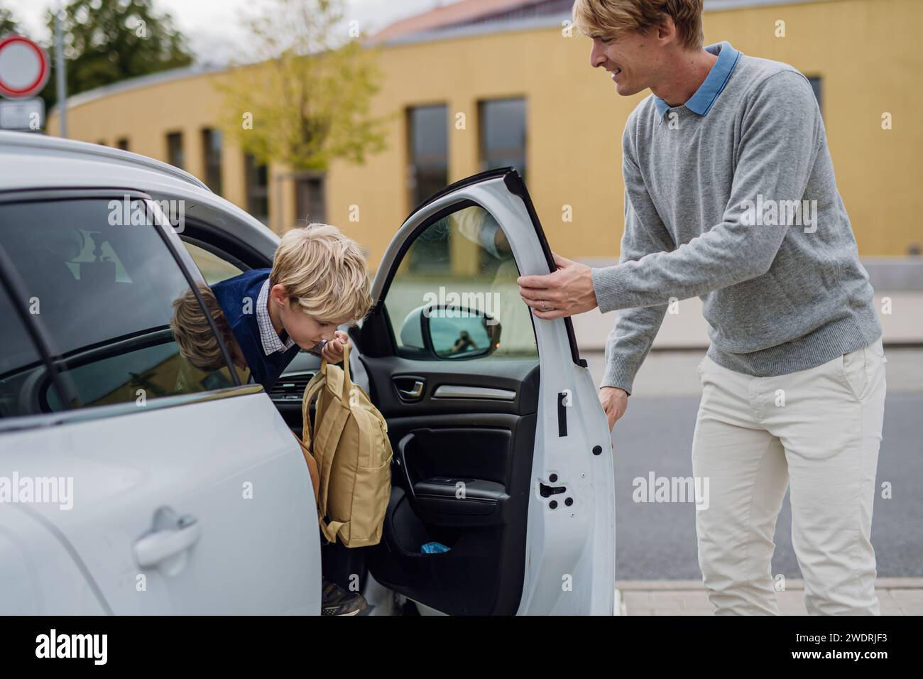 Children getting into the car, father taking them to school and ...