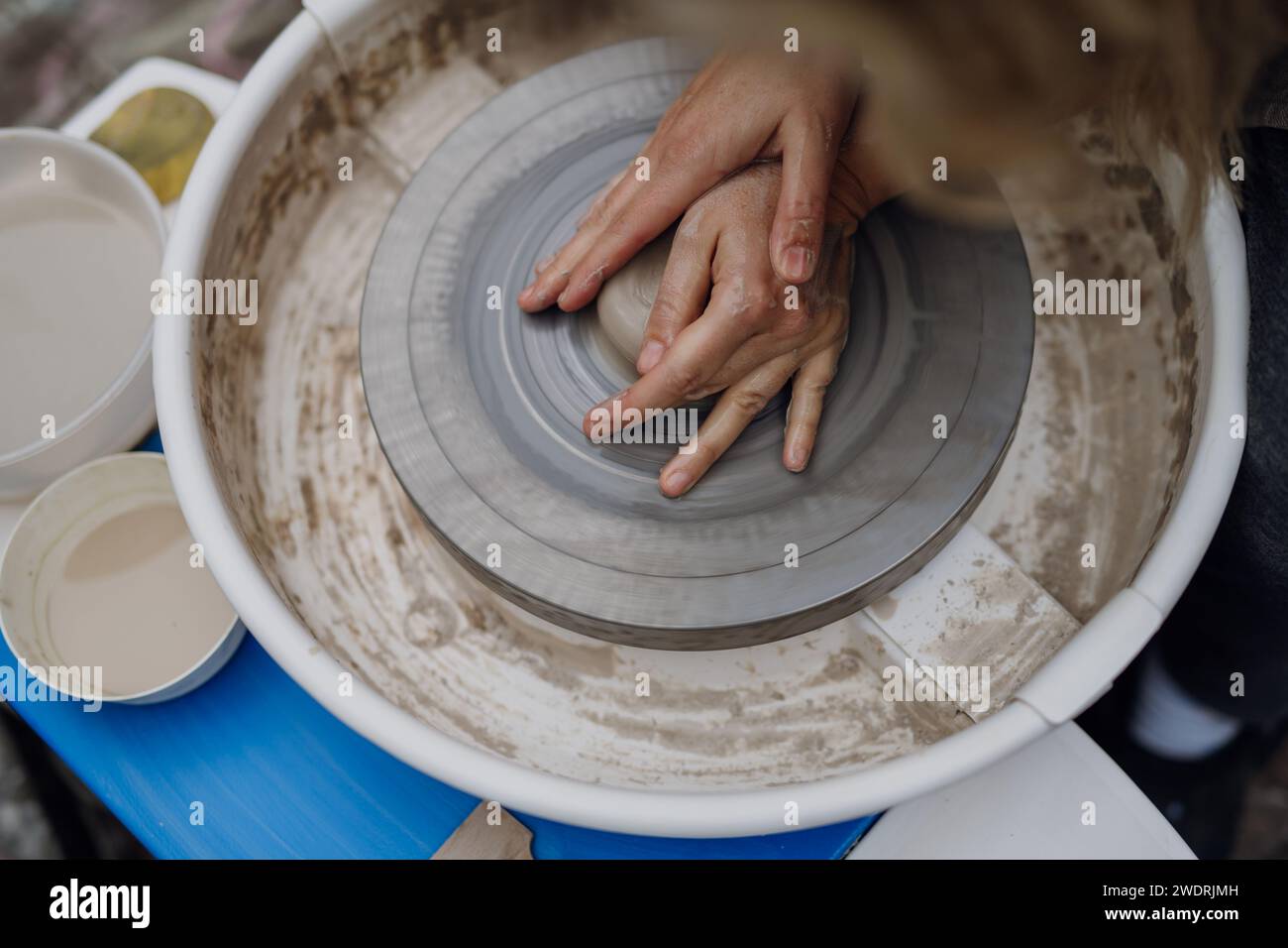Close up of Mother teaching son how make pottery on pottery wheel ...