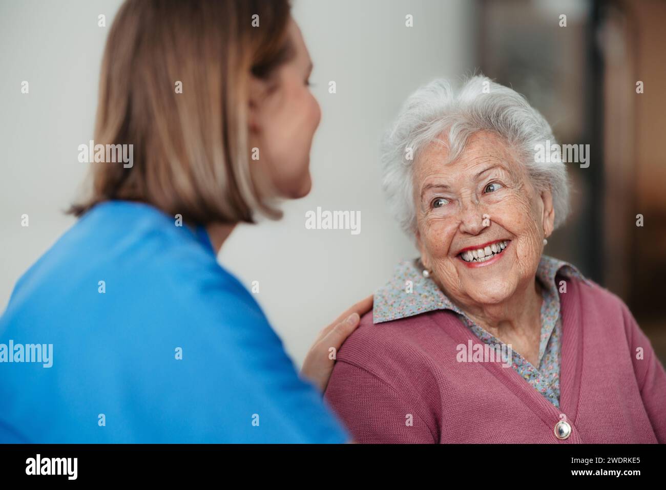 Portrait of nurse and senior patient talking in hospital corridor ...