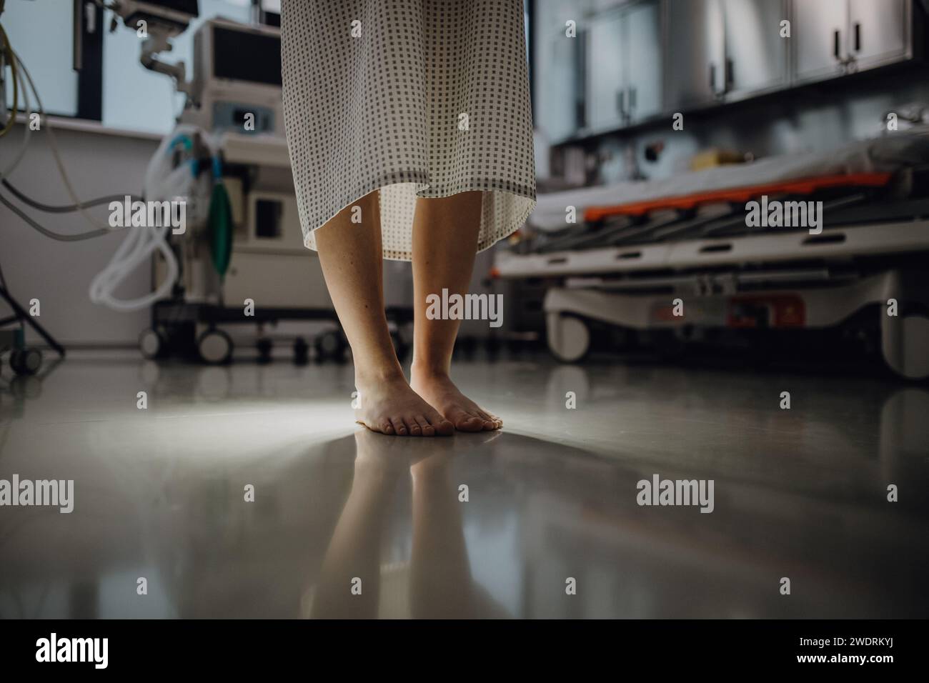 Close up of barefoot legs of patient, standing by hospital bed in ...