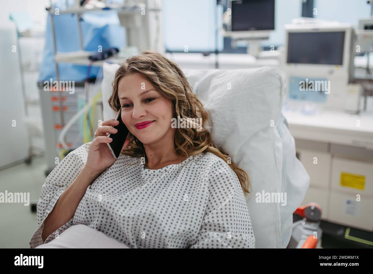 Woman phone calling from hospital room after successful surgery ...