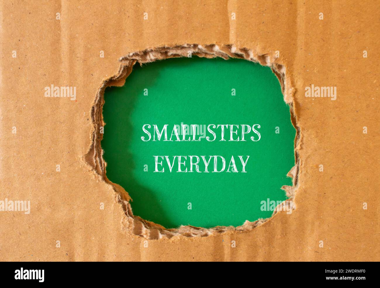 Small steps everyday lettering on ripped cardboard paper with green ...